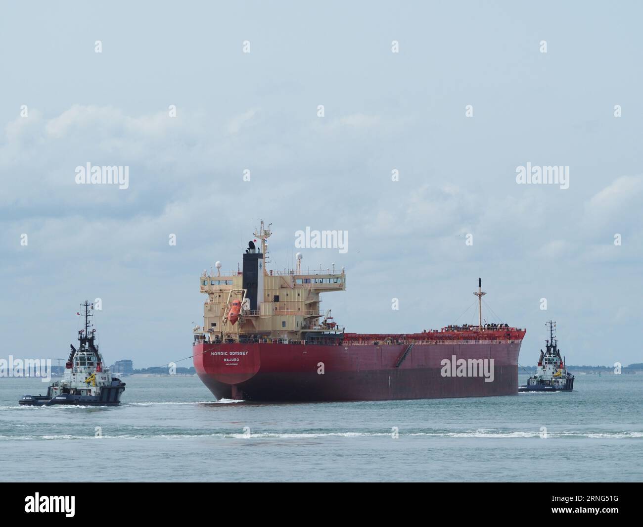 Oil tanker ship Nordic Odyssey with tug boat at stern and bow ...