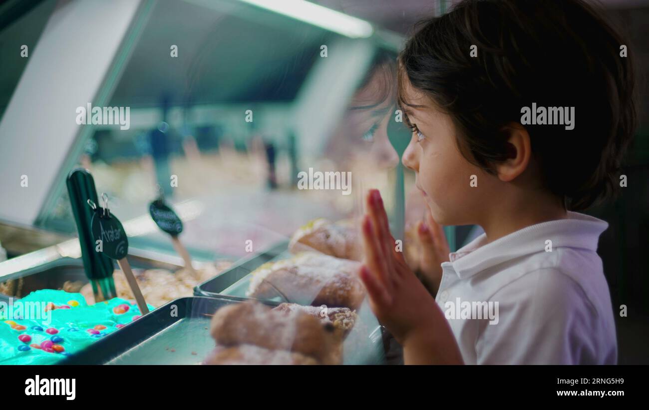 Kid at Ice-Cream Shop, Leaning on Counter and Examining Different ...