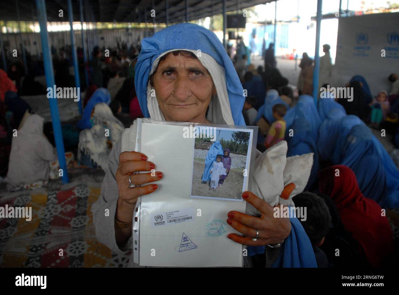An Afghan refugee woman shows her family picture at the United Nations ...
