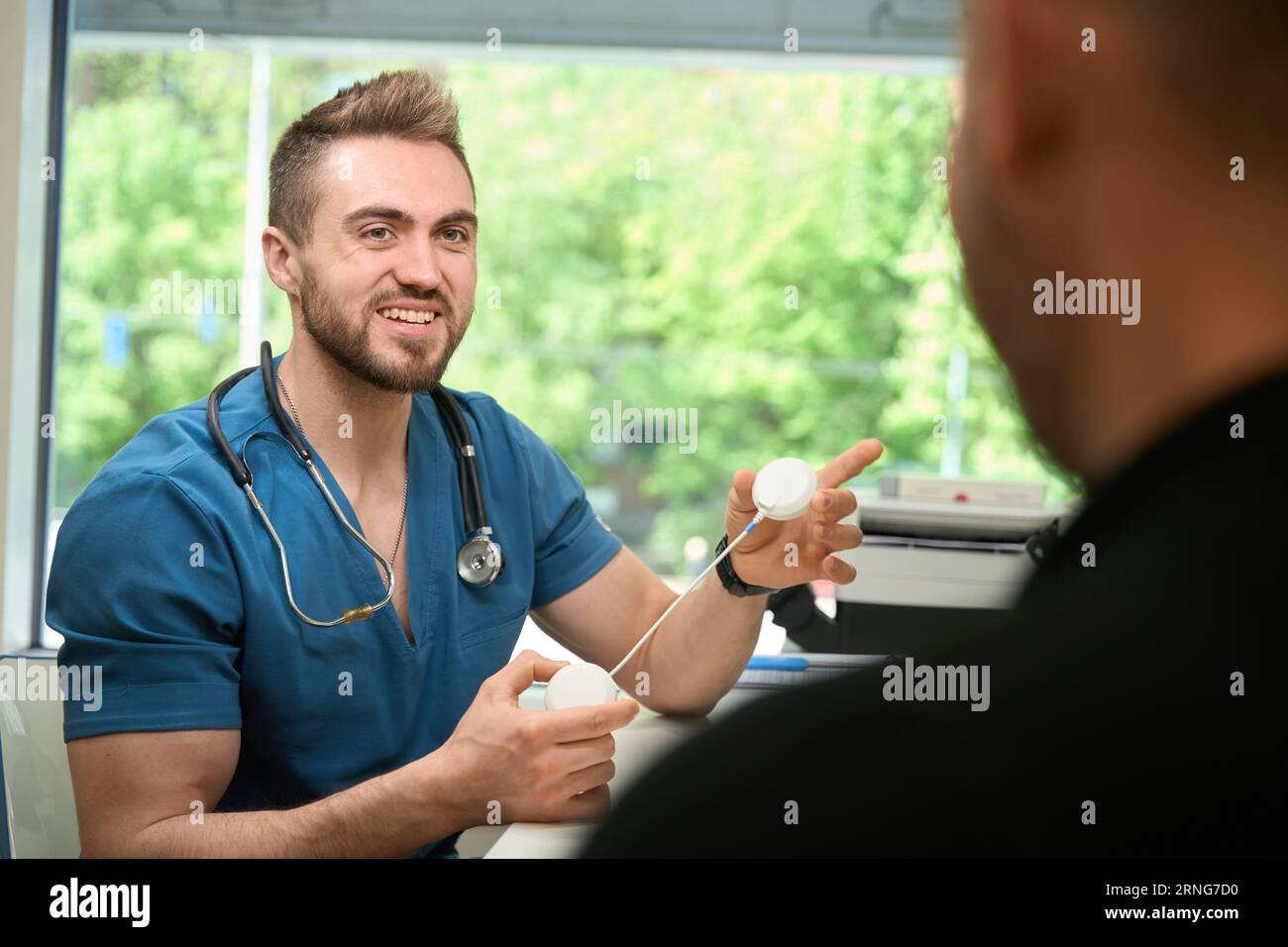 Friendly physiotherapist telling client about electrical muscle ...