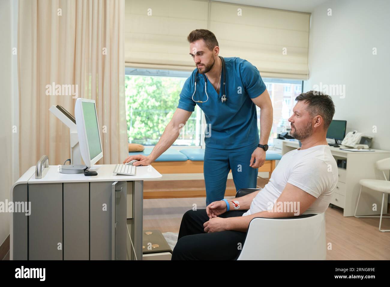 Cardiologist monitoring patient ECG tracing on computer screen Stock ...