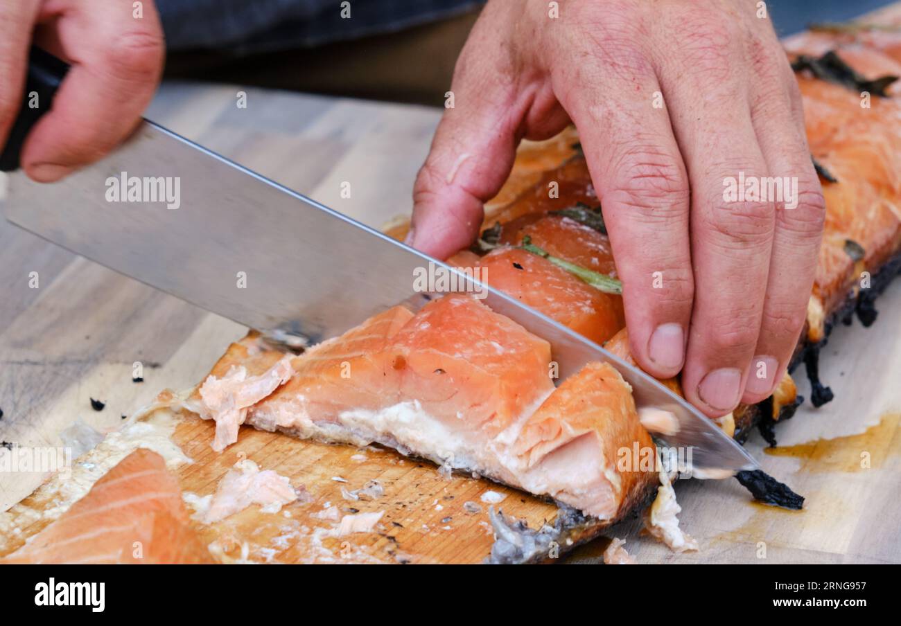 Chef cutting Traditional Indigenous prepartation of salmon filet with ...