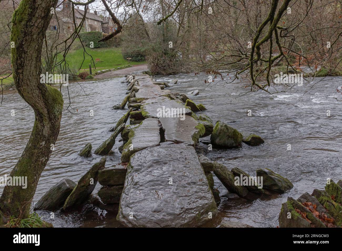 Ancient man made clapper bridge across a fast flowing ford in te Winter ...