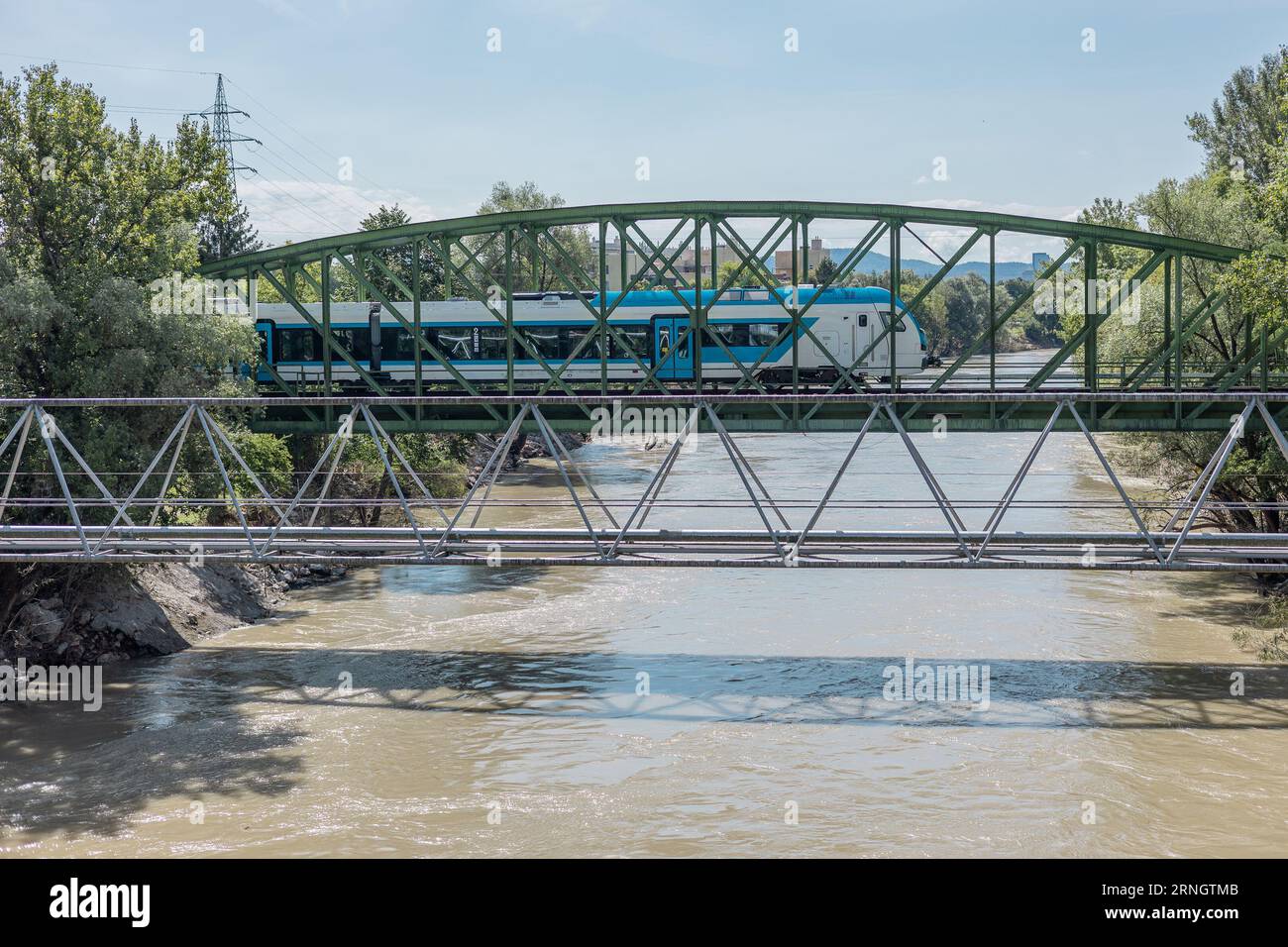 Train crossing a metal girder train bridge over Sava river in Slovenia ...