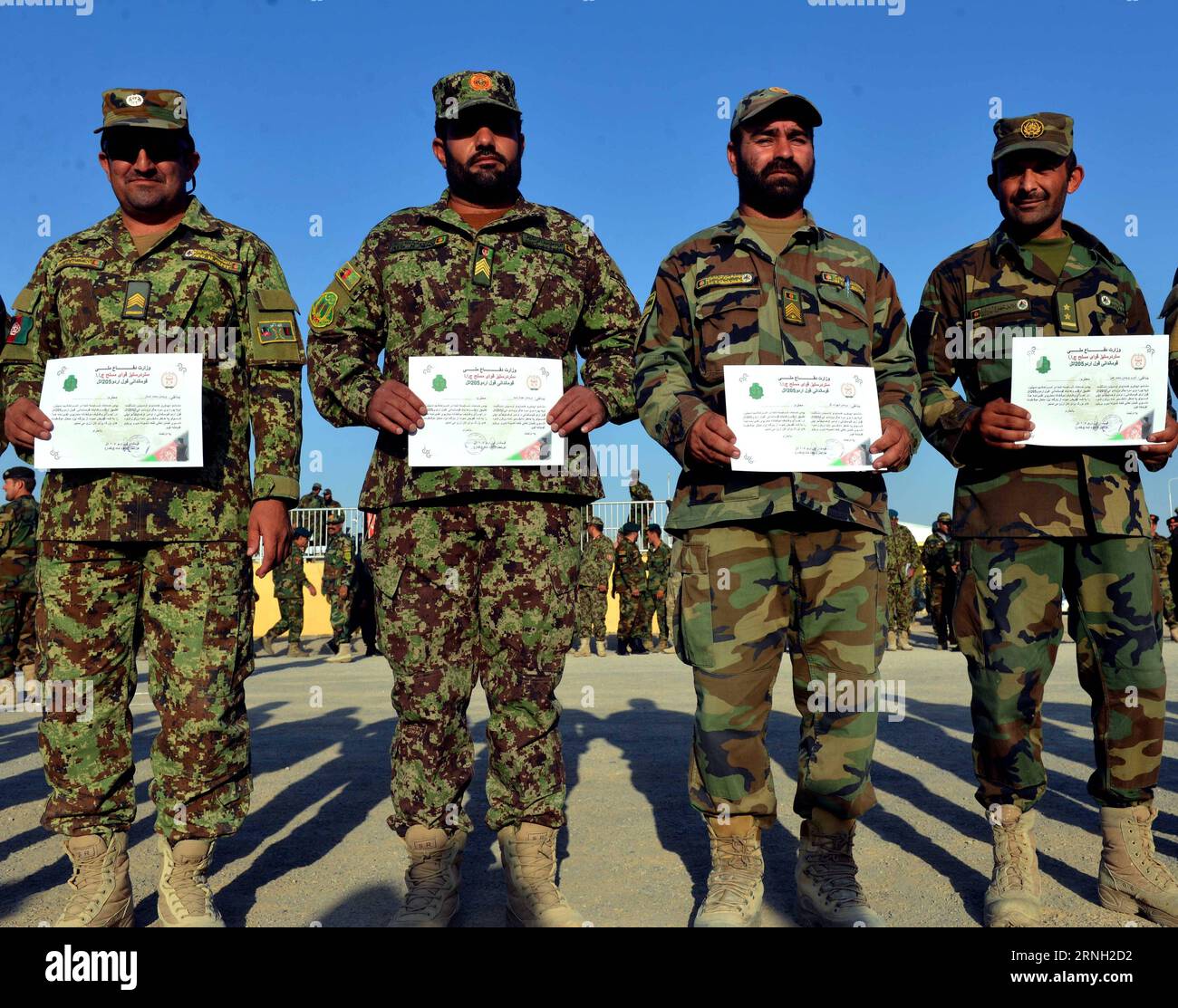 Afghan soldiers show their certificates during their graduation ...