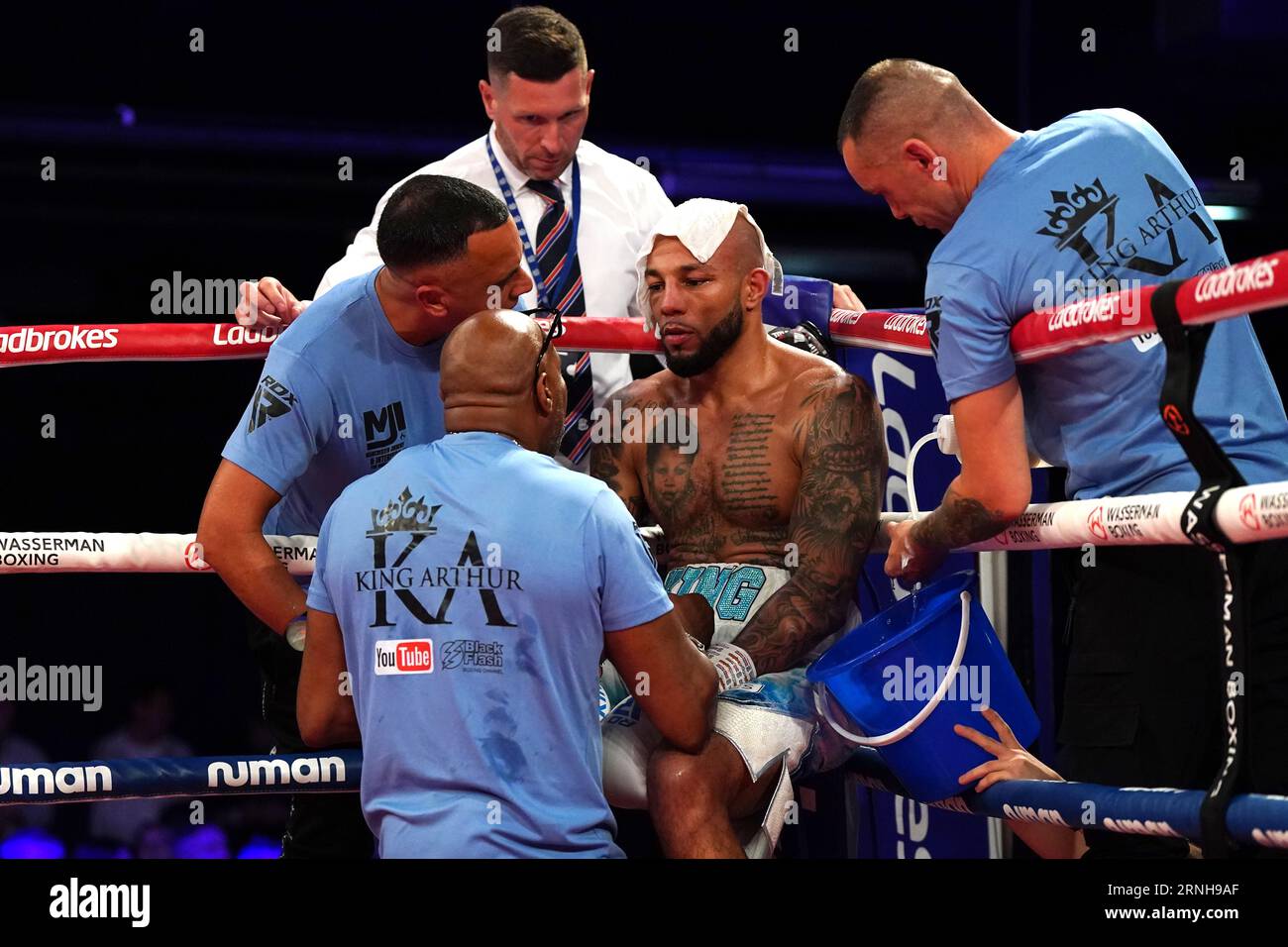 Lyndon Arthur (centre) is checked by the ring doctor between rounds in ...