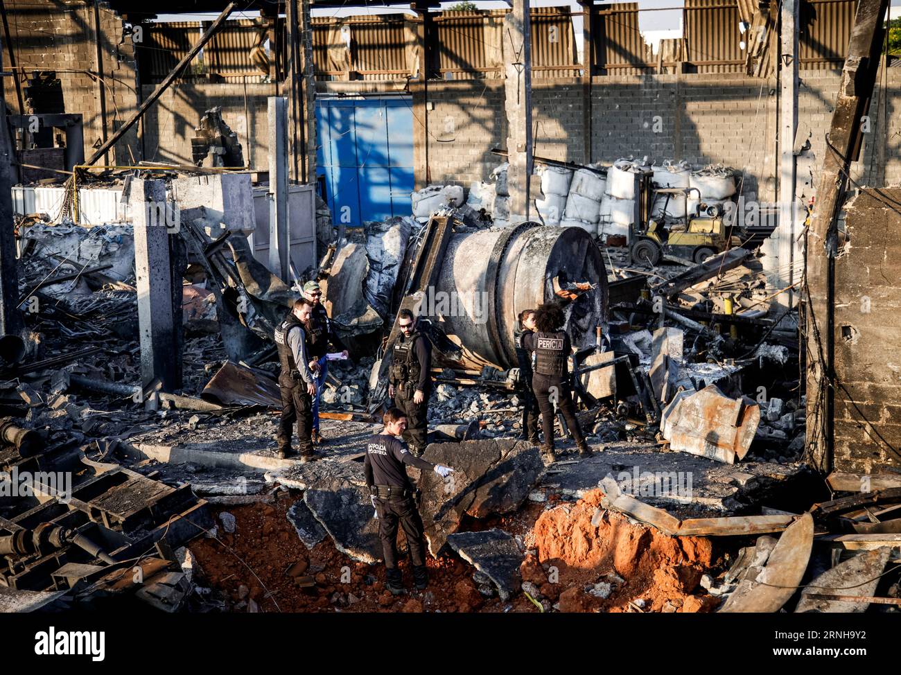 Police stand amid the debris of a metal factory destroyed by an ...