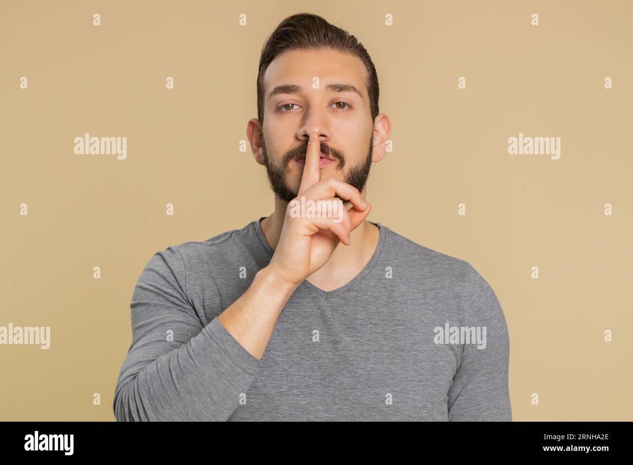 Shh be quiet please. Young lebanese man presses index finger to lips ...