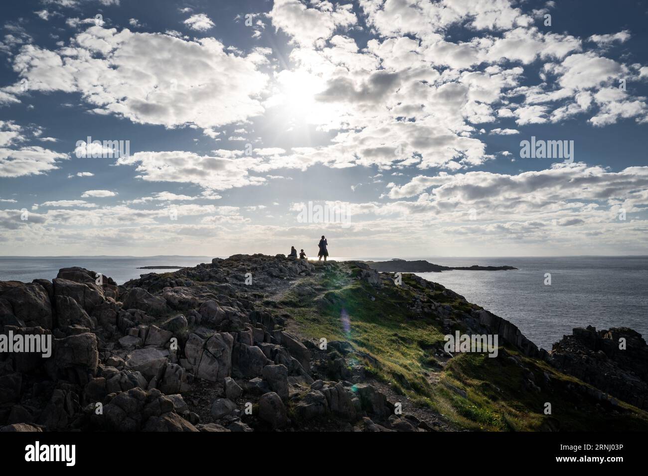 Traveller taking a picture with a cell phone on a rocky shoreline ...
