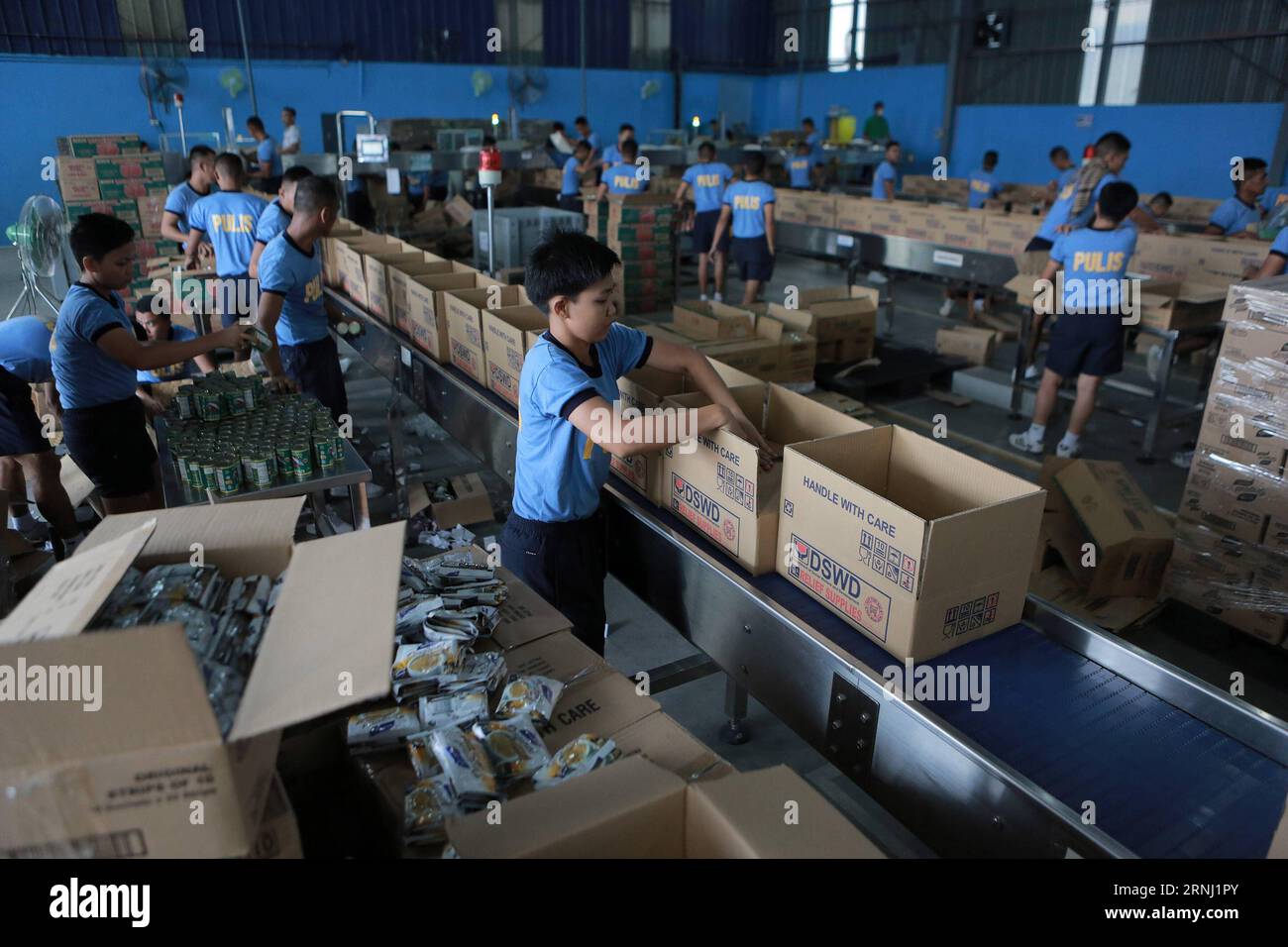 Personnel from the Philippine National Police (PNP) pack boxes with ...