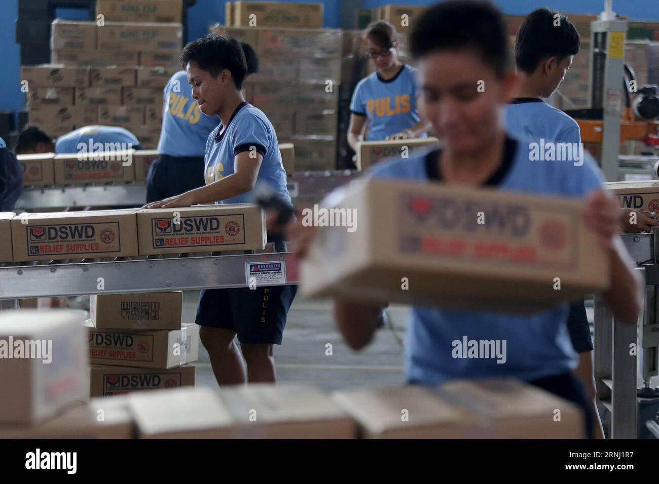 Personnel from the Philippine National Police (PNP) pack boxes with ...