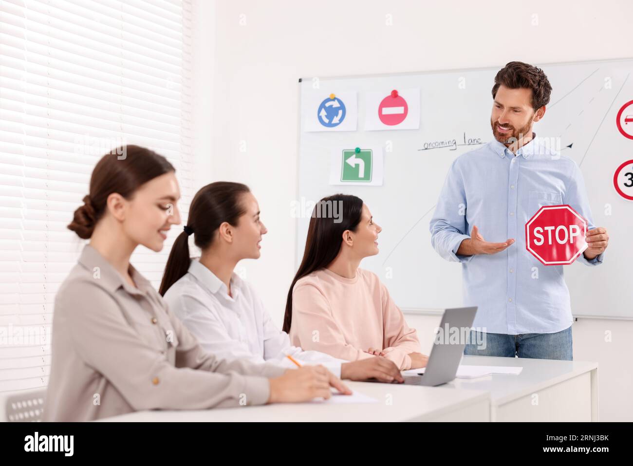 Teacher showing Stop road sign during lesson in driving school Stock ...