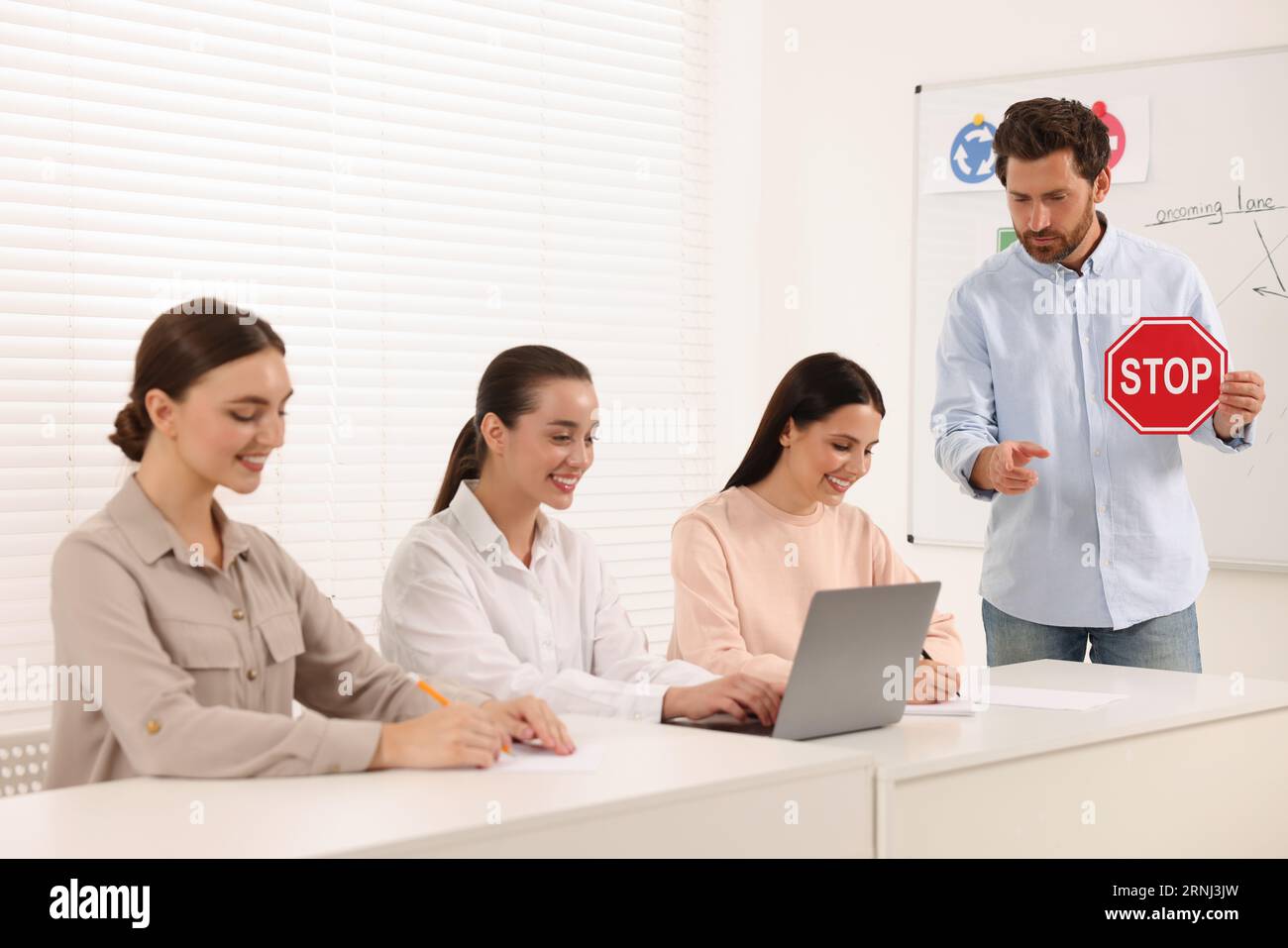 Teacher showing Stop road sign during lesson in driving school Stock ...
