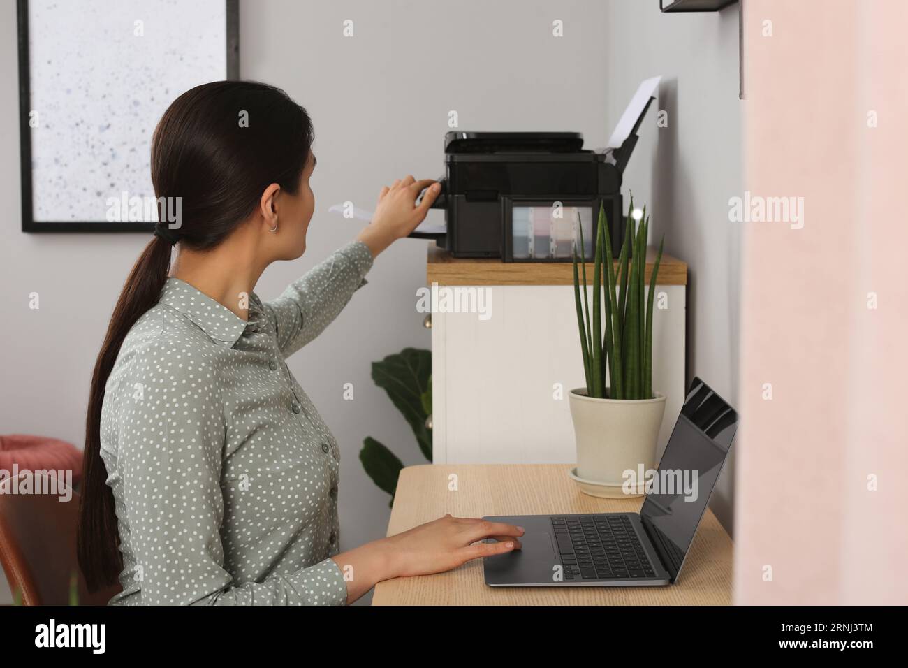 Woman using modern printer at workplace indoors Stock Photo - Alamy