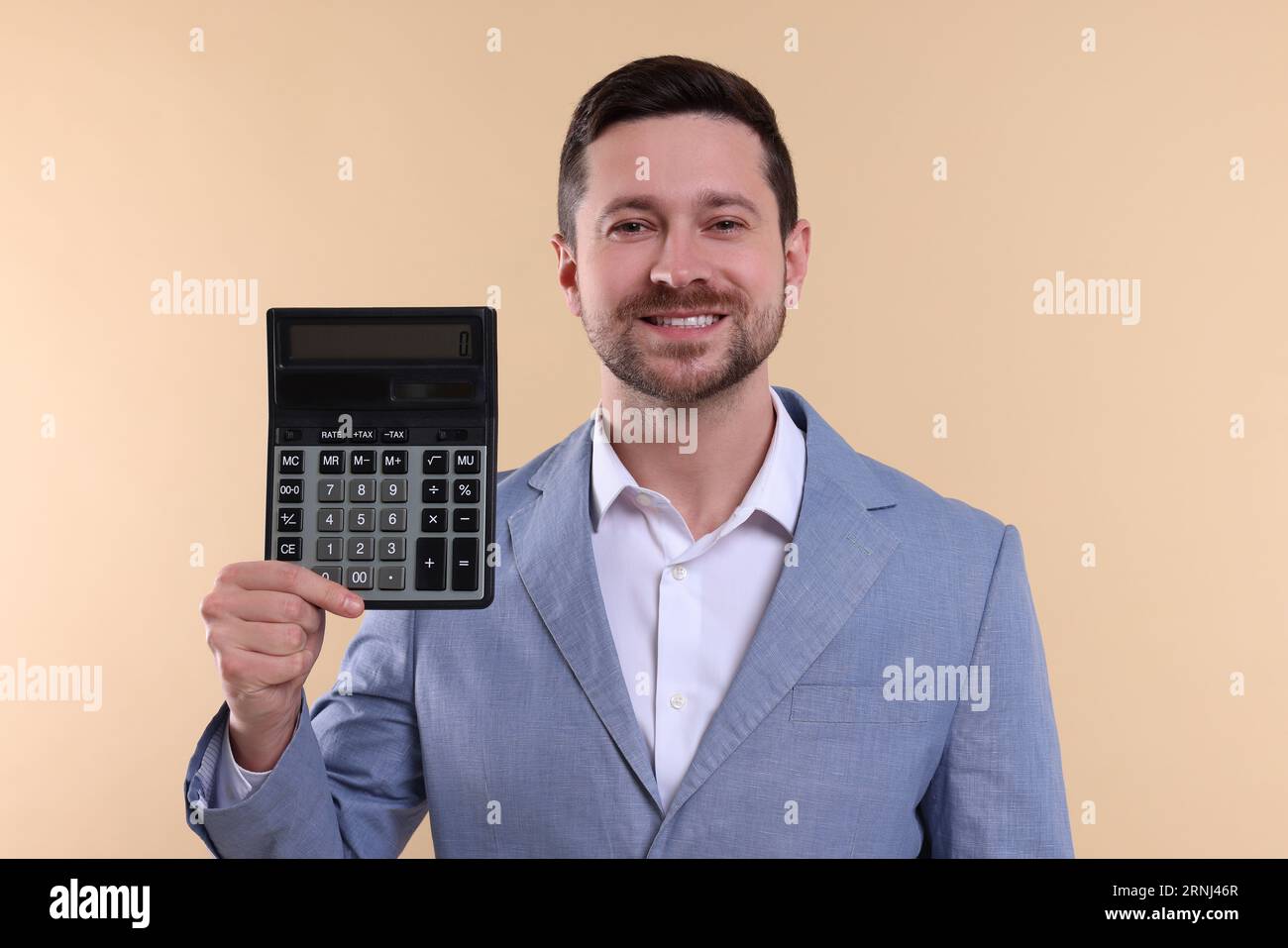 Happy accountant with calculator on beige background Stock Photo - Alamy