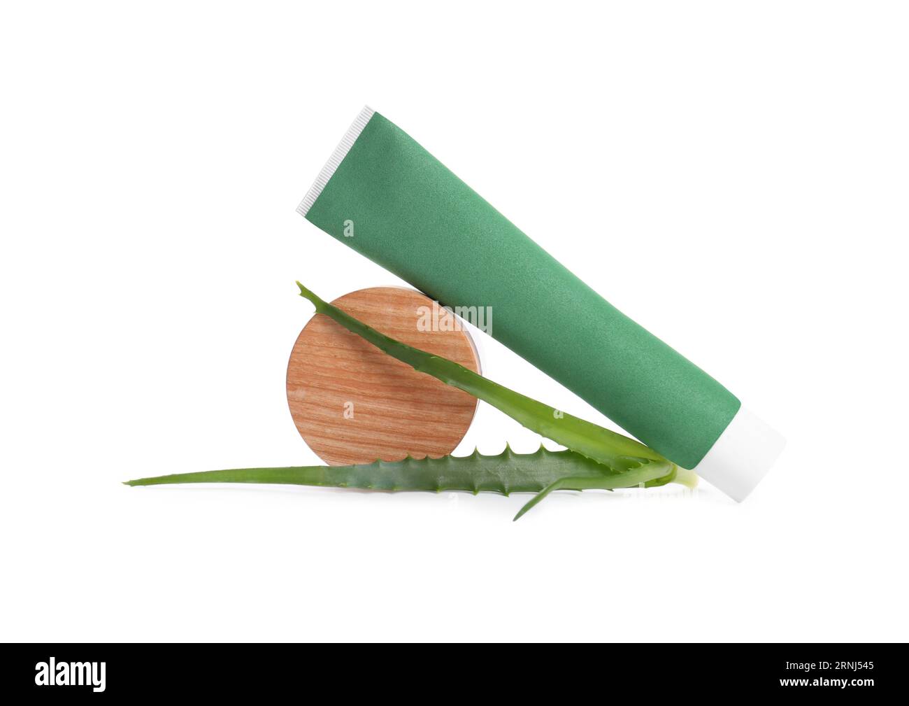 Tube of toothpaste, aloe vera leaves and wooden decor on white ...