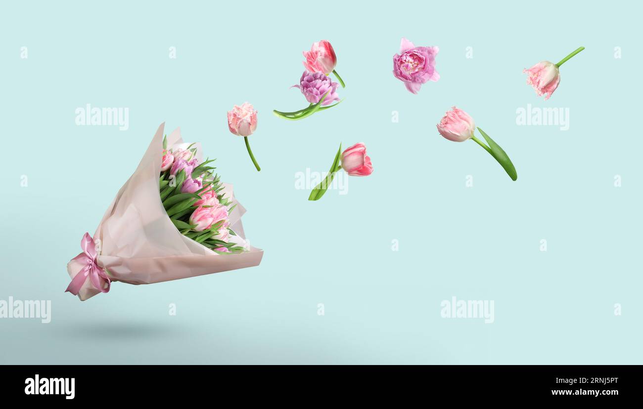 Tulip flowers flying to beautiful bouquet on light blue background ...