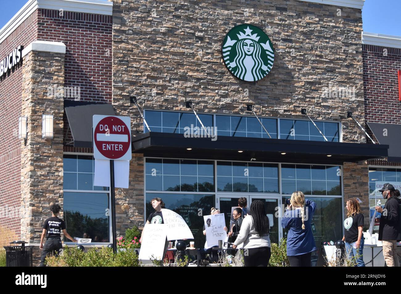 Starbucks workers walk off the job holding placards to support the strike at the Starbucks ...