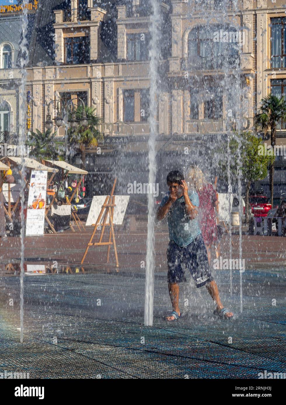 Batumi, Georgia. 08.19.2023 Boy is playing in the fountain. Wet child ...