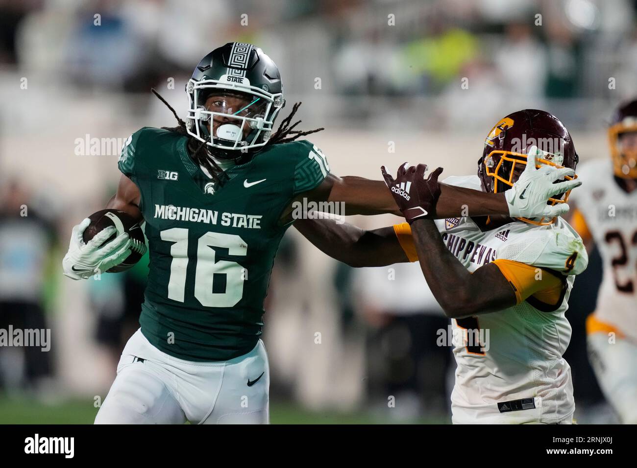 Michigan State wide receiver Christian Fitzpatrick (16) stiff arms ...