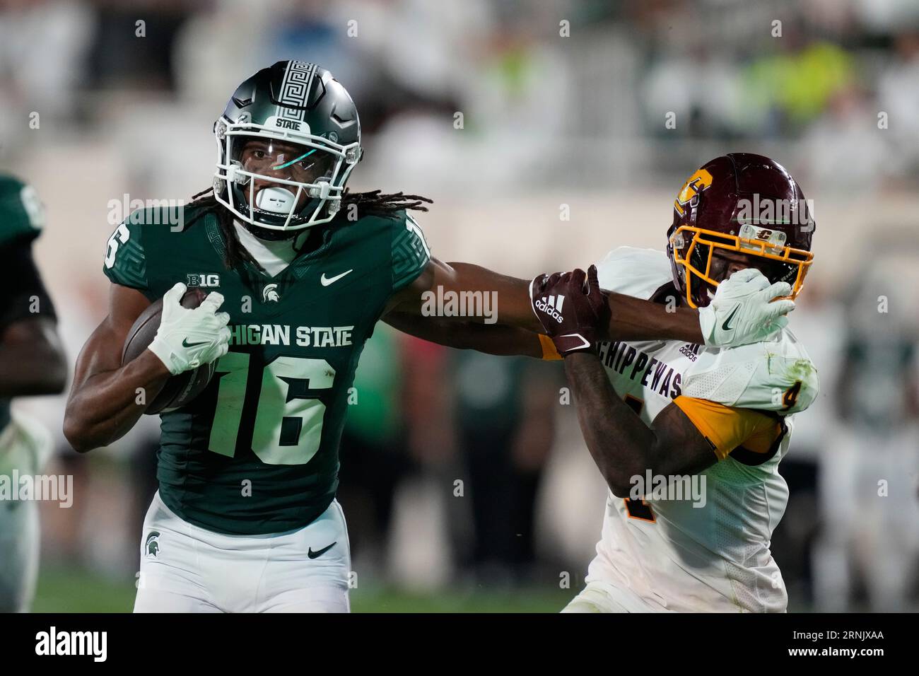 Michigan State wide receiver Christian Fitzpatrick (16) stiff arms ...