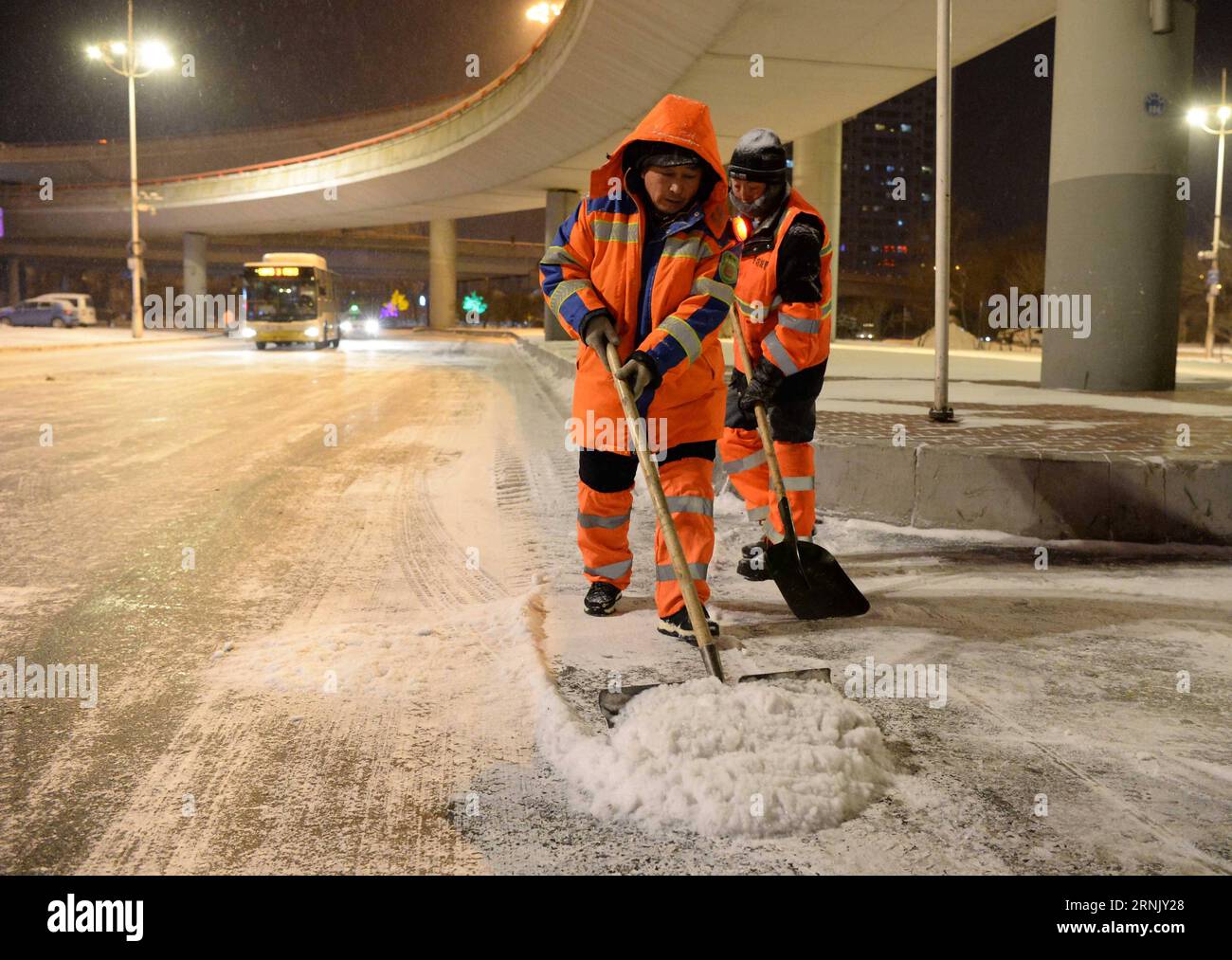 City workers clear snow on a road in Harbin, capital of northeast China ...