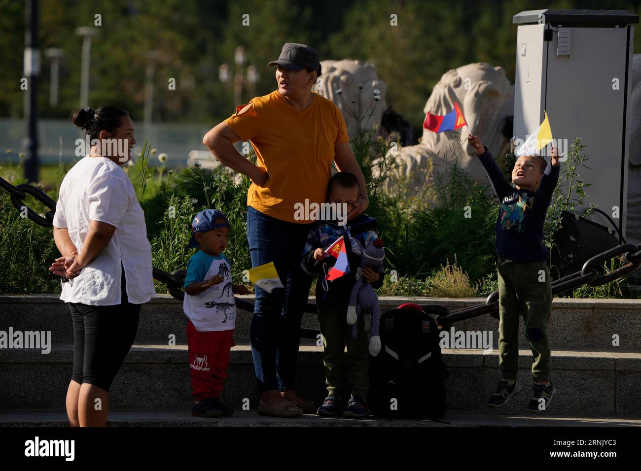 A family with Mongolian and Vatican national flags wait Mongolian ...