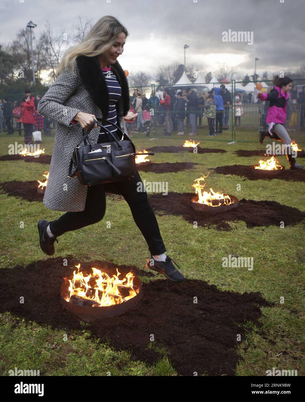 (170315) -- VANCOUVER, March 15, 2017 -- A woman leaps over a bonfire ...