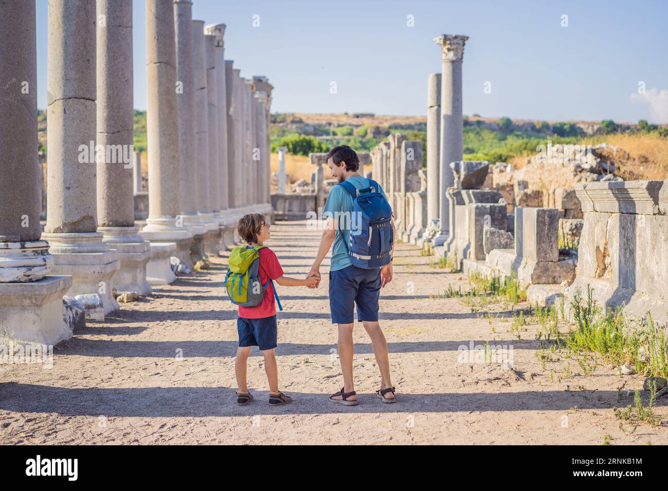 dad and son tourists at the ruins of ancient city of Perge near Antalya Turkey. Traveling with ...