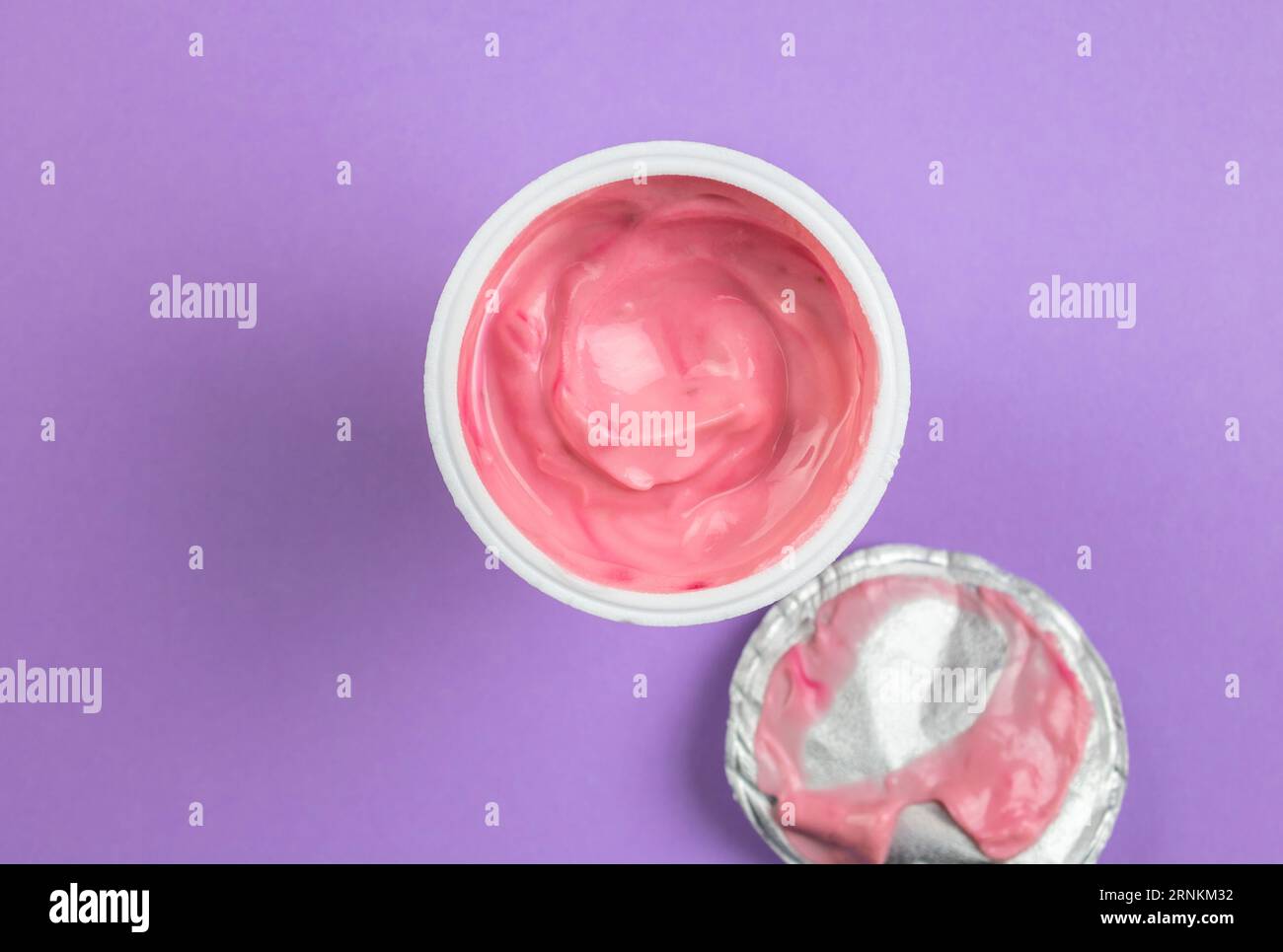 Pink yogurt cup - top view of strawberry yoghurt on lilac background ...