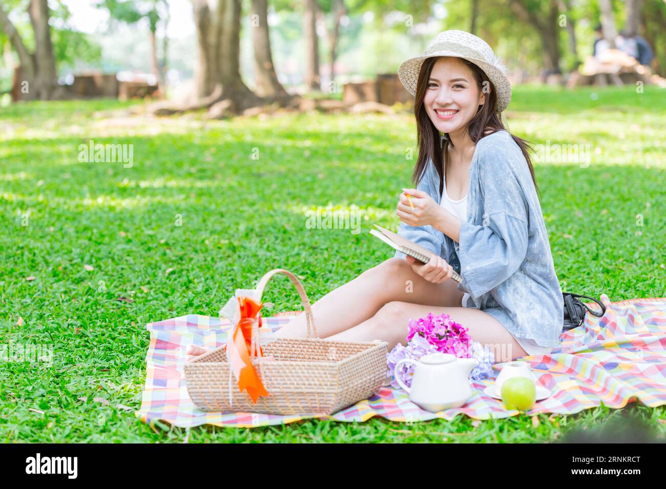 Happy Asian beautiful lady sitting relax happy picnic outdoors at park ...