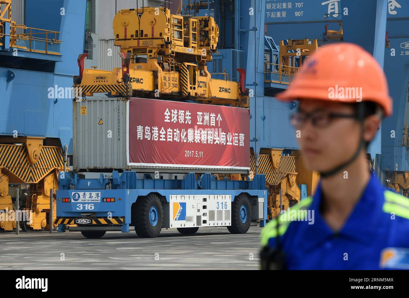 (170511) -- QINGDAO, May 11, 2017 -- A shipping container is loaded onto an unmanned vehicle by ...