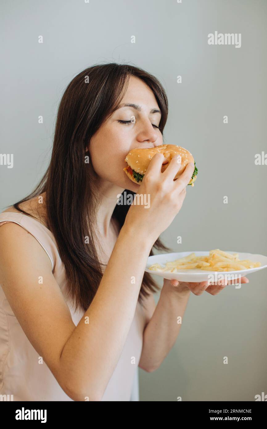 Woman eating burger potatoes hi-res stock photography and images - Alamy