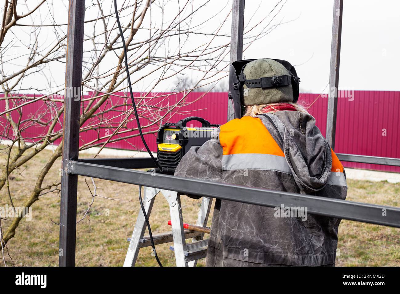 the welder makes welding of metal structures from a profile pipe with ...