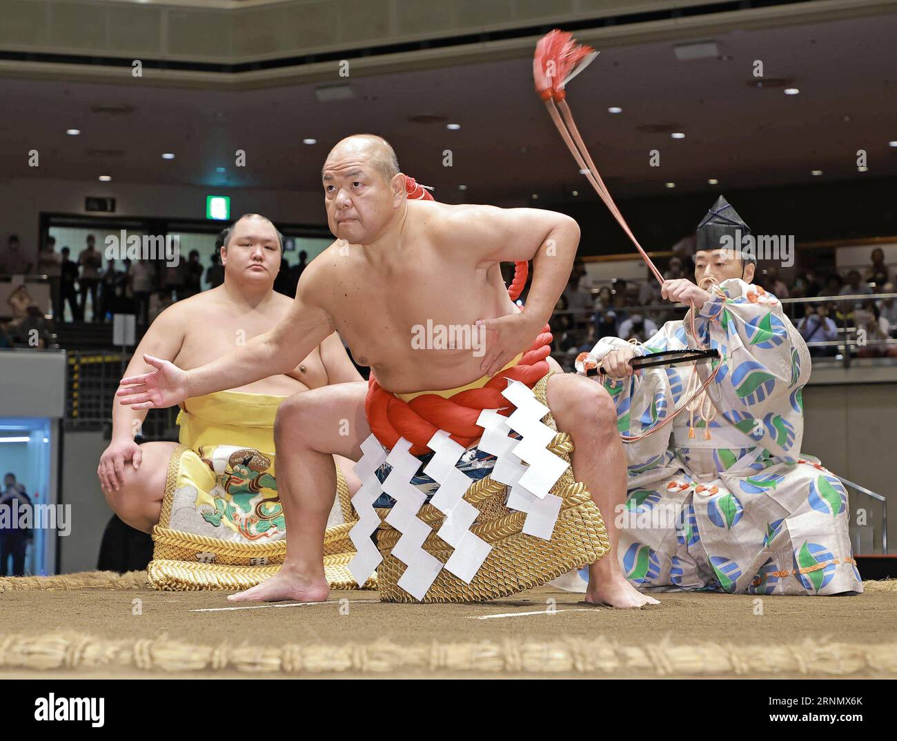 Japan Sumo Association head Hakkaku (C) performs a ring-entering ...