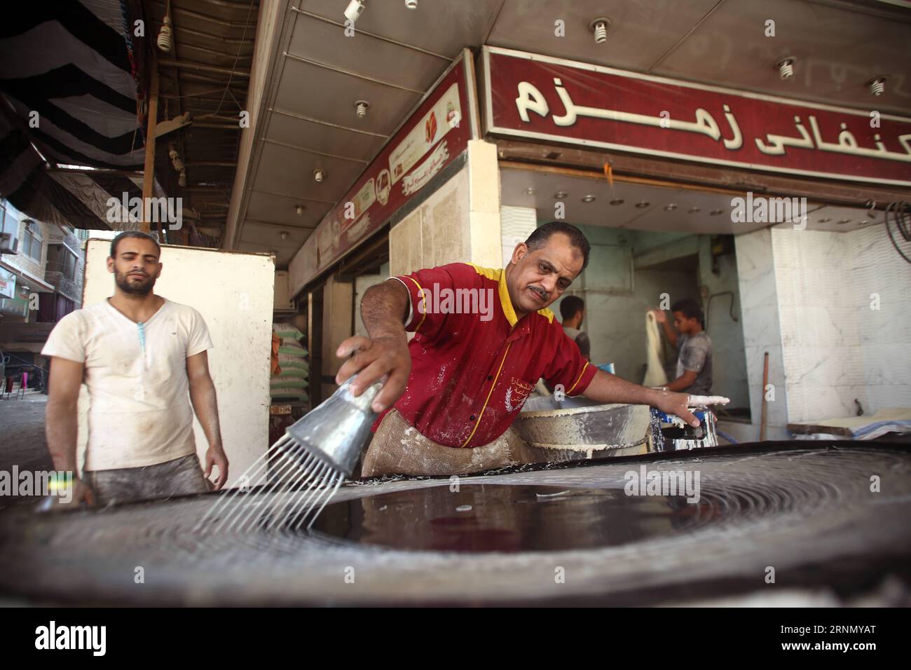 (170616) -- GIZA, June 16, 2017 -- An Egyptian baker makes kunafa, a ...
