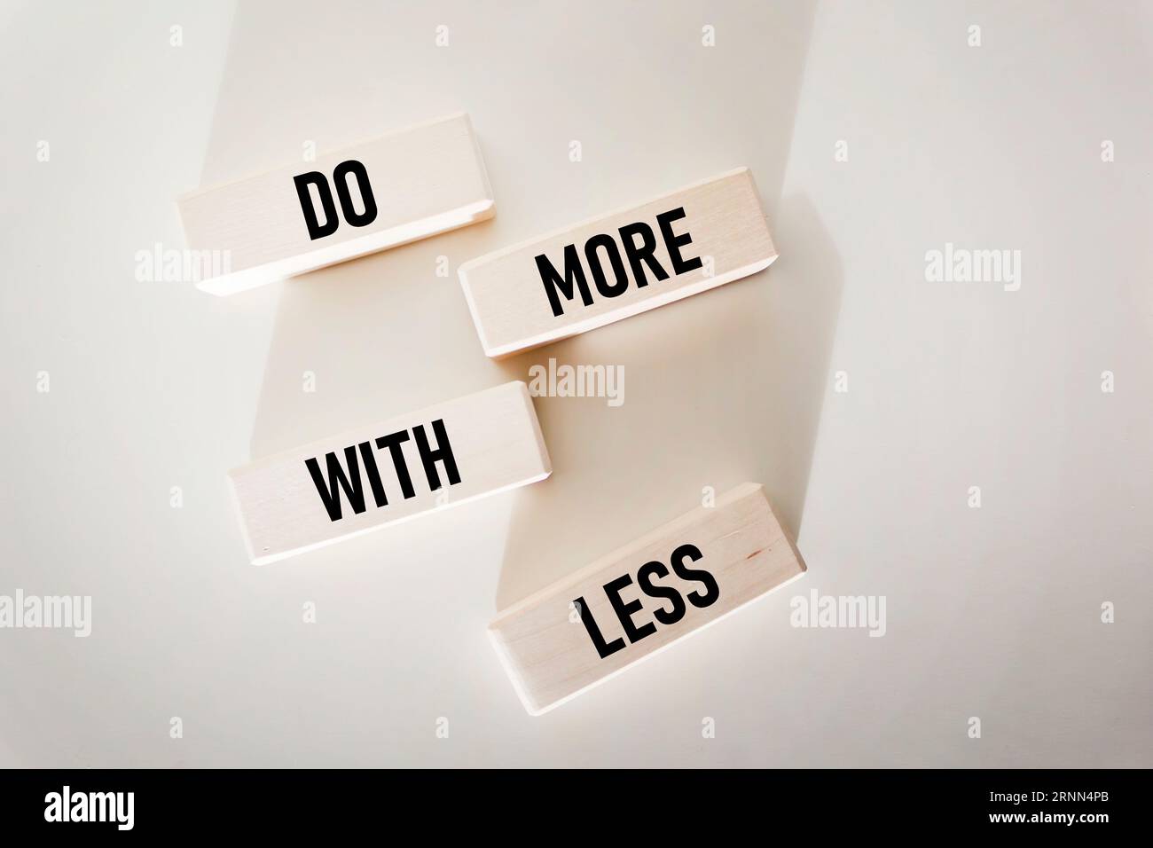 Conceptual words Do more with less on wooden blocks and white ...