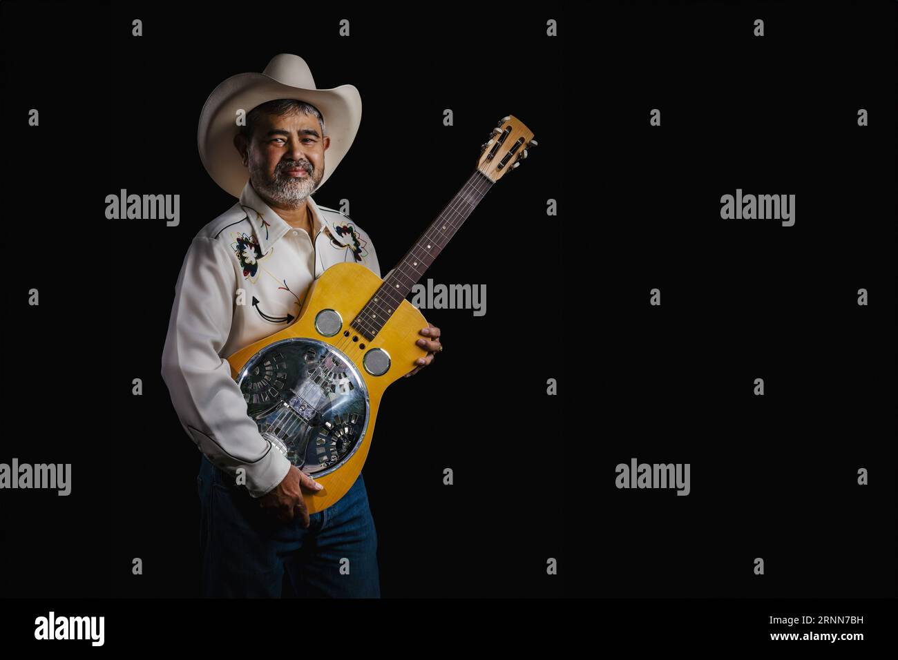 Portrait of bearded Asian musician dons cowboy attire, clutching a ...