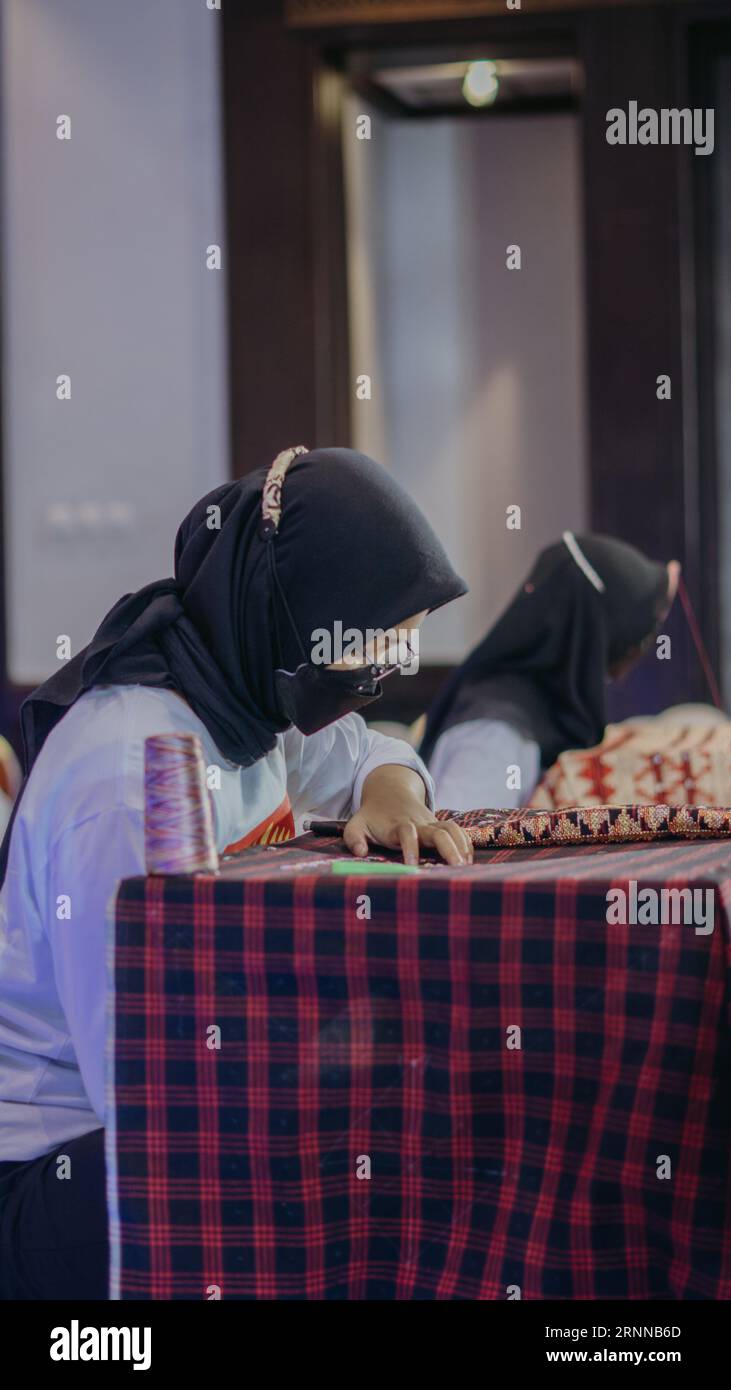 A woman is weaving cloth, or so-called traditional tapis cloth Stock ...