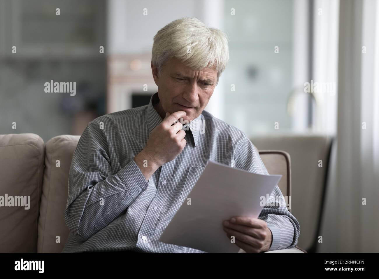 Serious worried senior retired man reading document, paper letter Stock ...