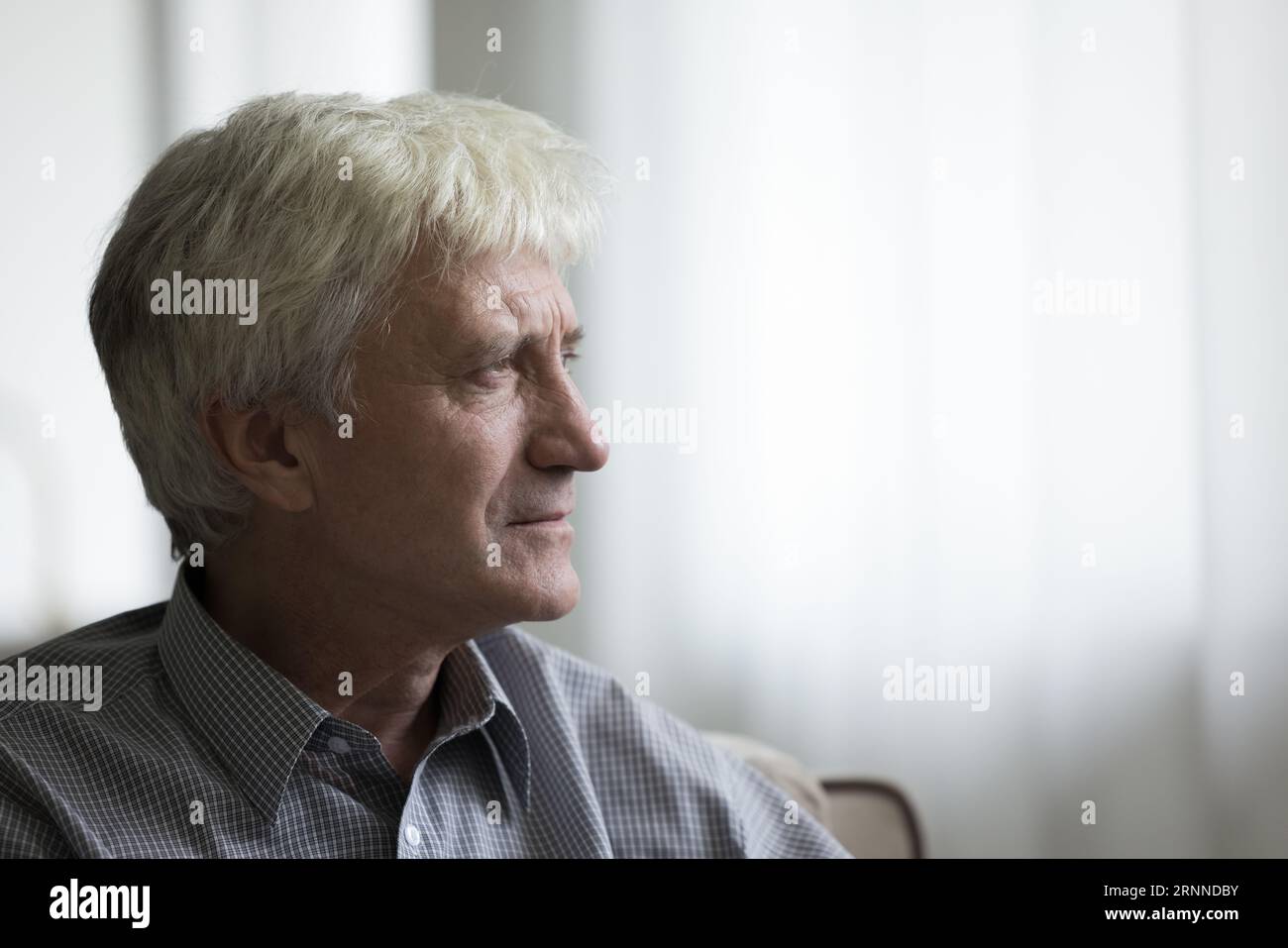 Serious pensive older retired man looking at window away, thinking ...