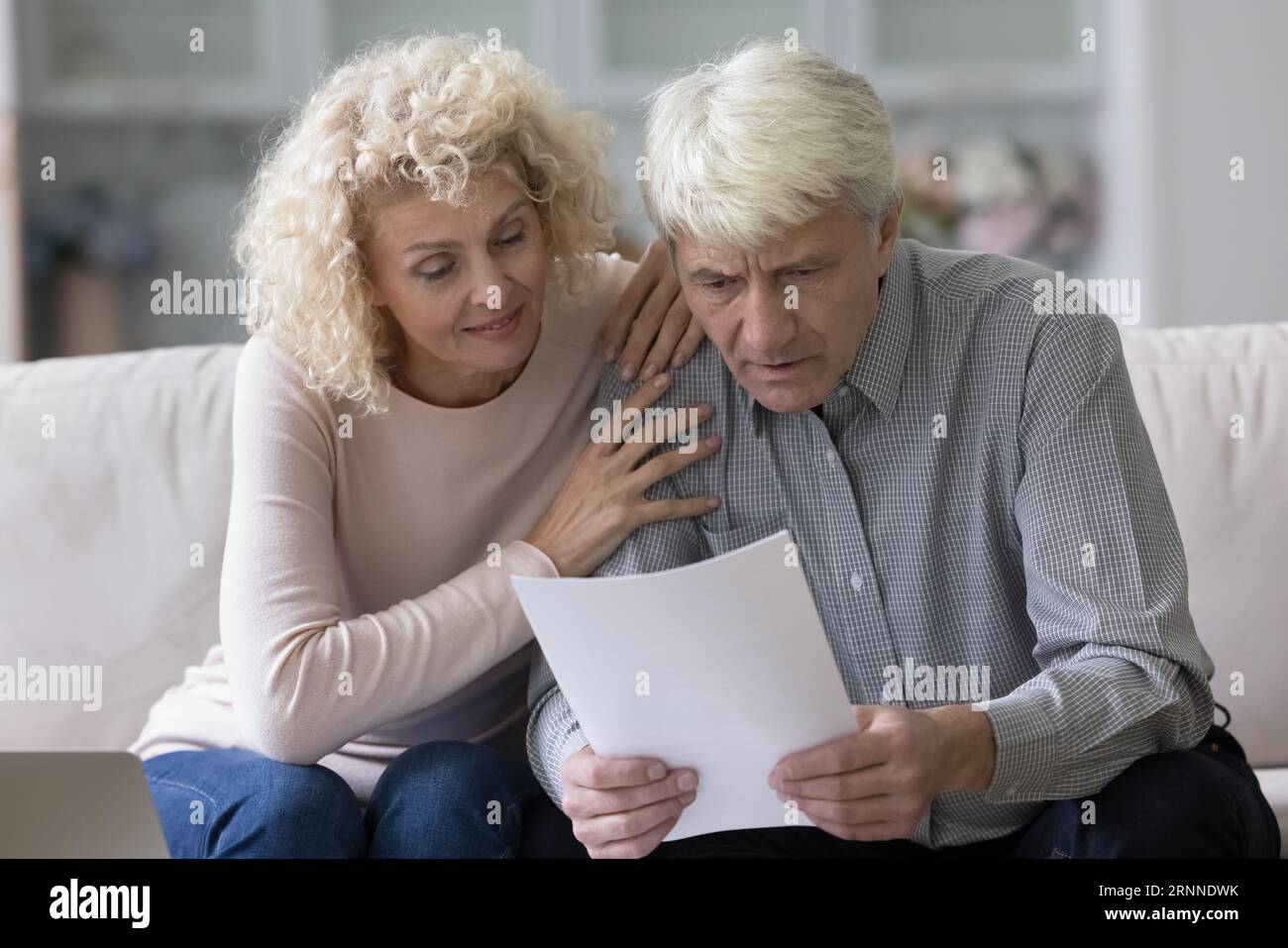 Puzzled concerned senior husband and wife reading document Stock Photo ...