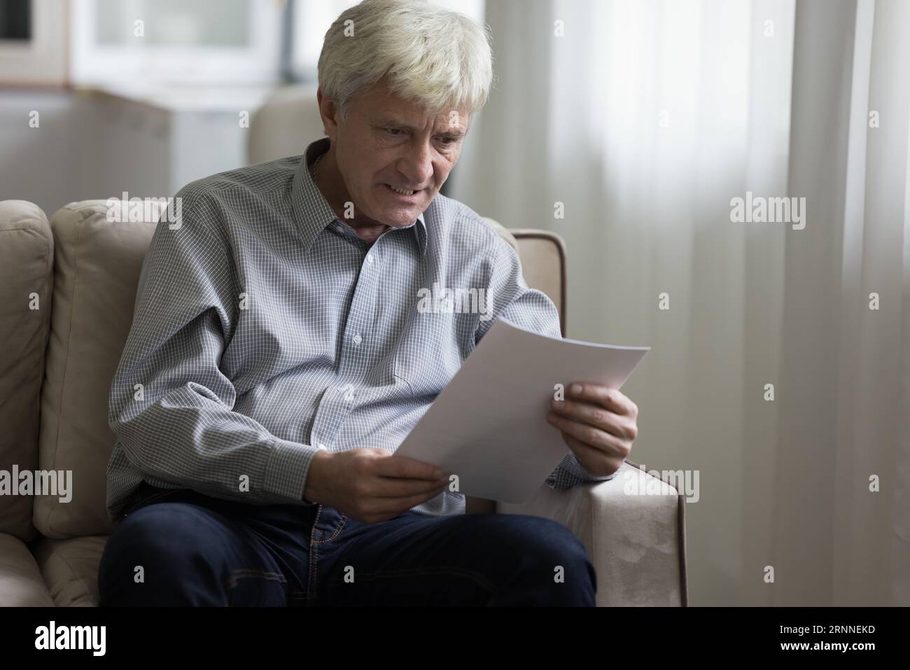 Angry stressed senior man staring at document, reading paper letter ...