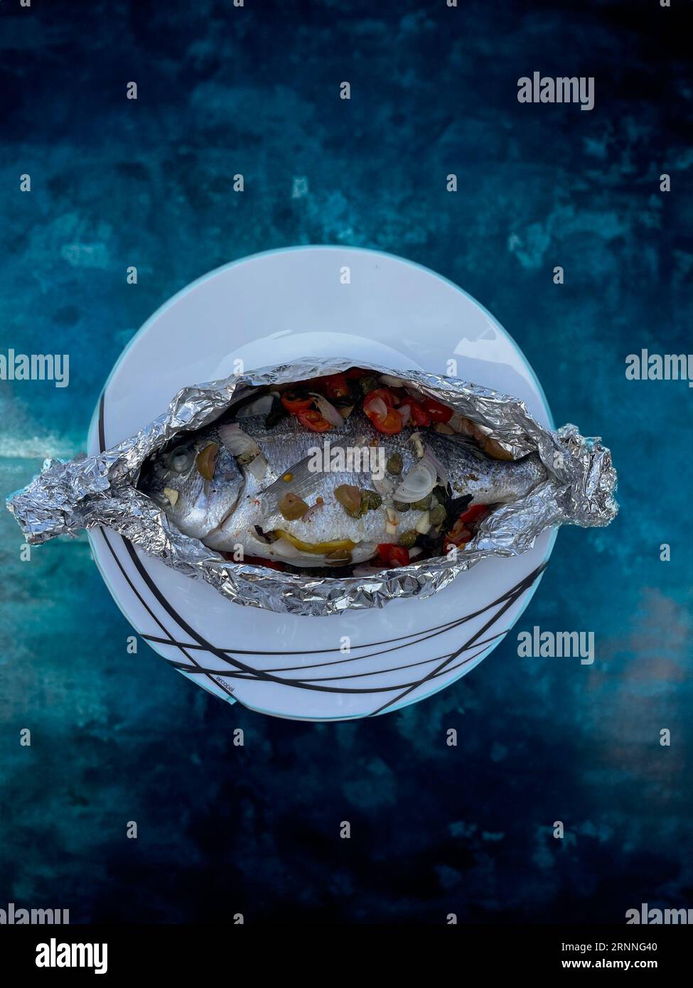 baked sea bream with capers cherry tomatoes onion and lemon ready for ...
