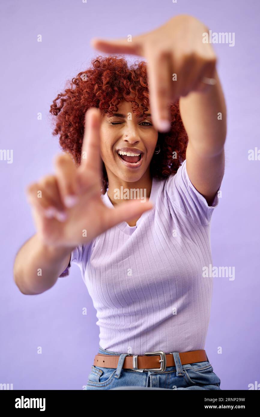 Portrait, hands frame and happy woman wink in studio isolated on a ...