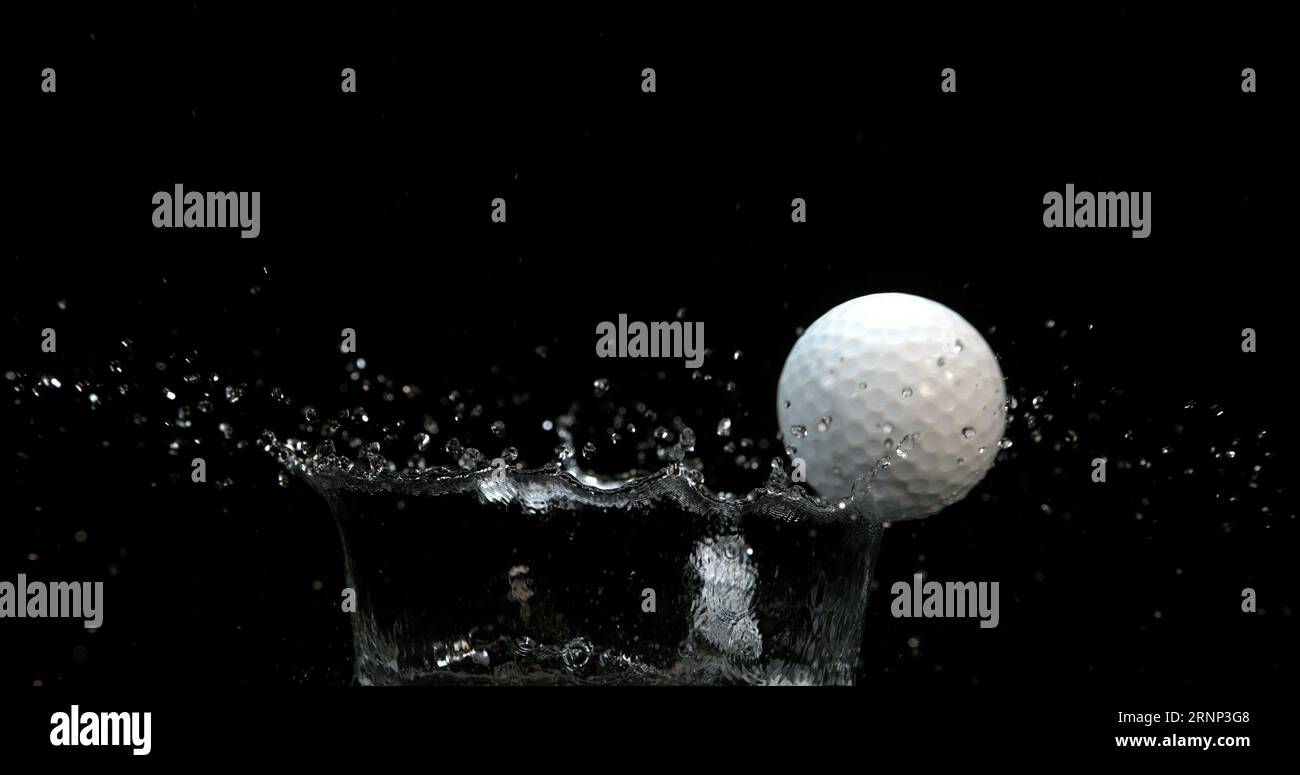 Golf's Ball Falling into Water against Black background Stock Photo - Alamy