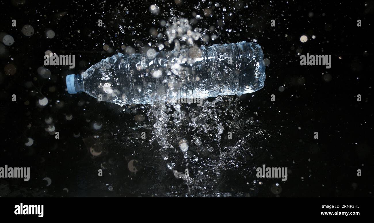 Bottle of Water falling on Water against Black Background Stock Photo ...