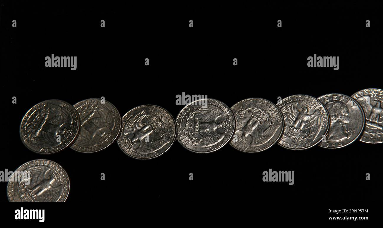 Quarter Dollar Coins Falling, Rolling and Sliding on Black Background ...