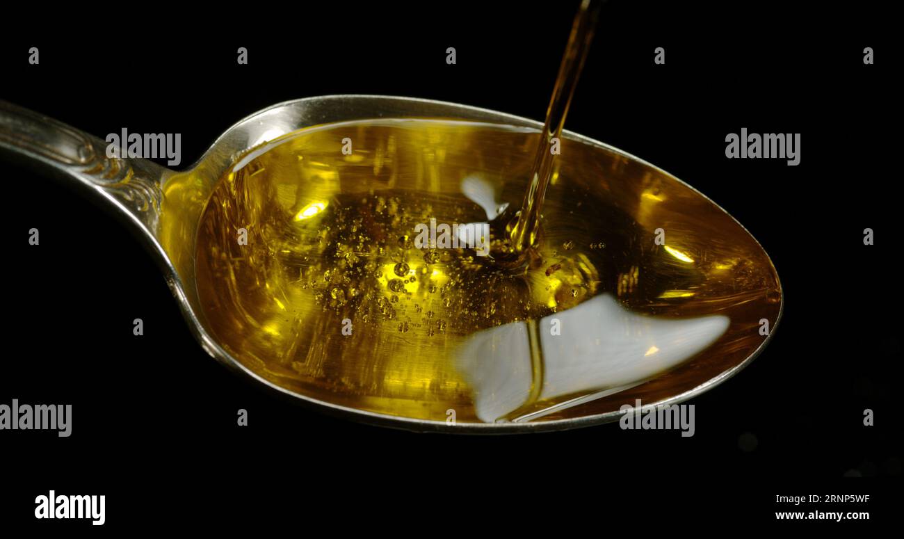 Olive Oil, Falling in a Spoon against Black Background Stock Photo - Alamy