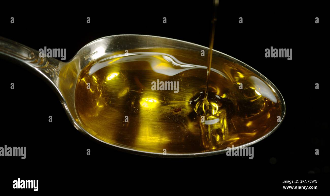 Olive Oil, Falling in a Spoon against Black Background Stock Photo - Alamy